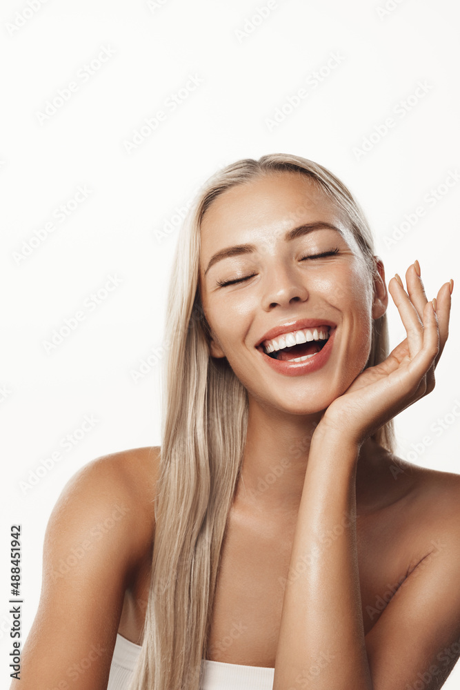 Vertical shot of beautiful blond woman model, laughing and smiling with ...