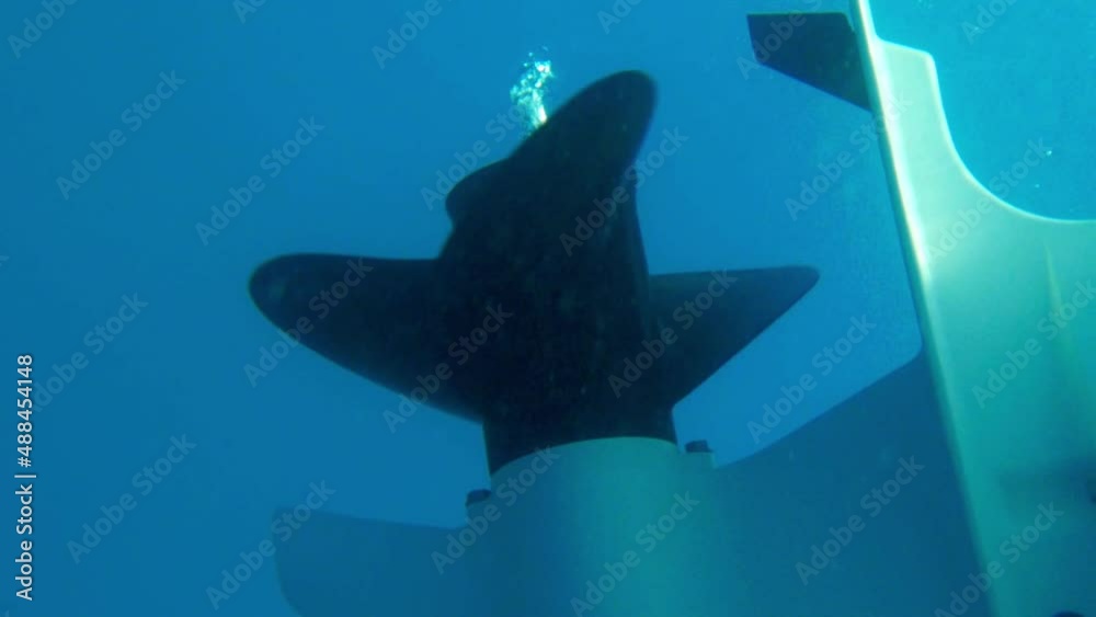 slow-motion undersea view of boat propeller spinning underwater ...