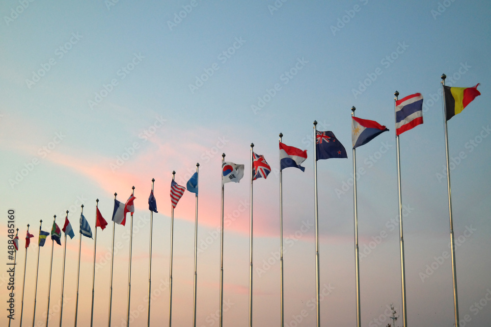 The flags of various countries are raised against the backdrop of ...