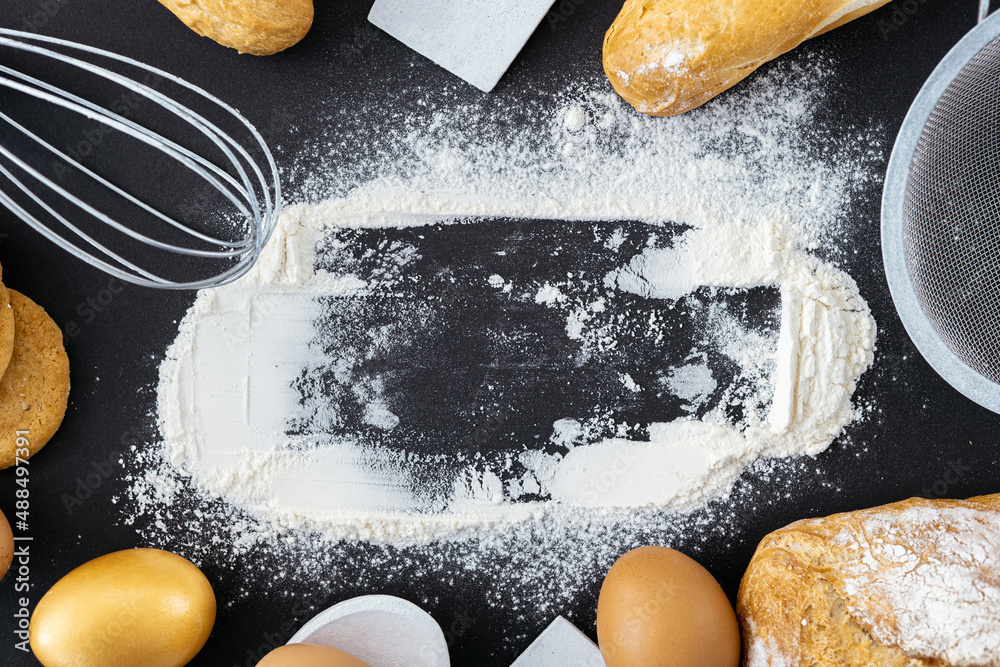 spilled flour on a black background with copyspace, eggs, bread ...