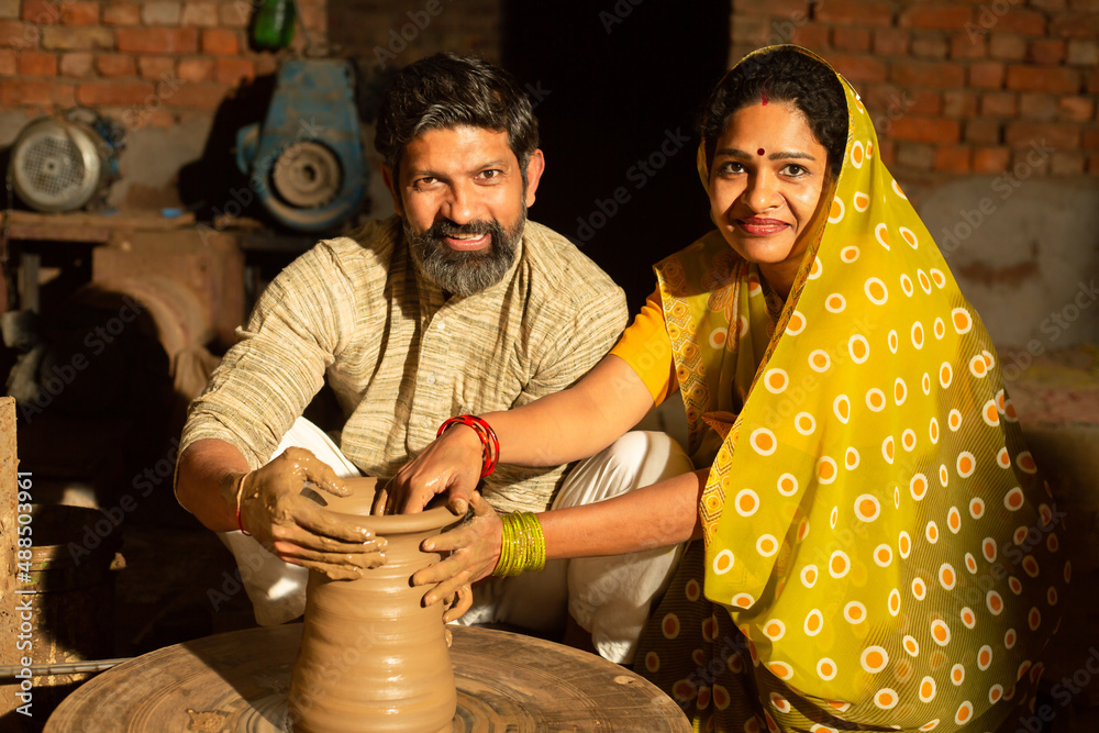 Portrait of happy indian couple pottery maker building clay pot ...