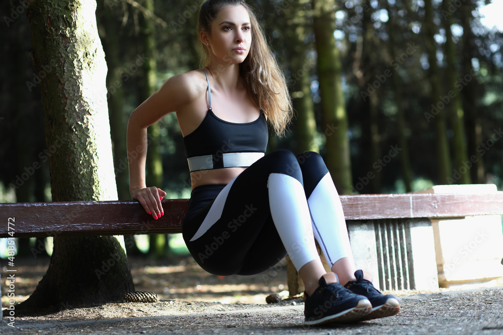 Serious sweaty girl doing push ups on bench in park, work hard on ...