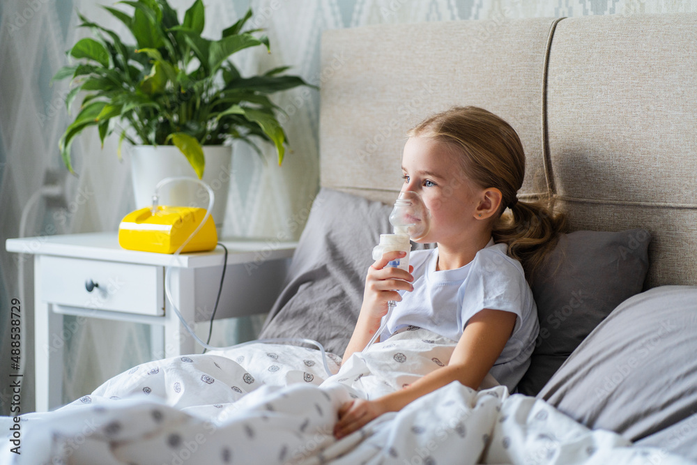 Sick little girl making inhalation with nebulizer to reduce coughing ...