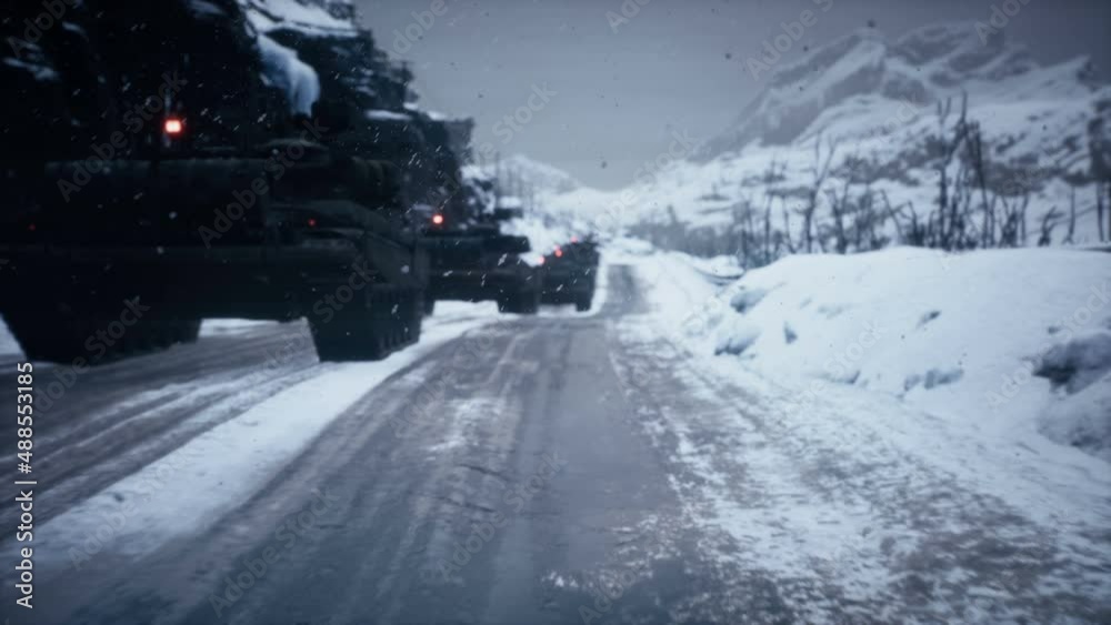 A tank convoy stands on a deserted winter road during a snowfall. A ...