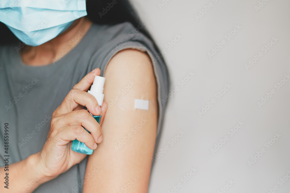 senior hand holding spray alcohol bottle, wearing medical face mask ...