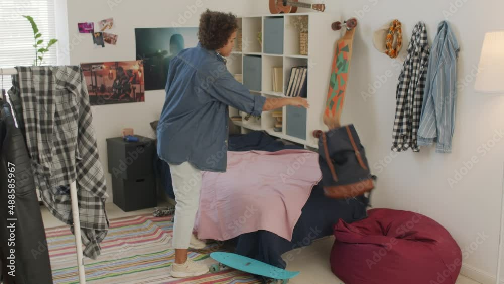 Locked-down of curly young Black girl coming back to her bedroom ...