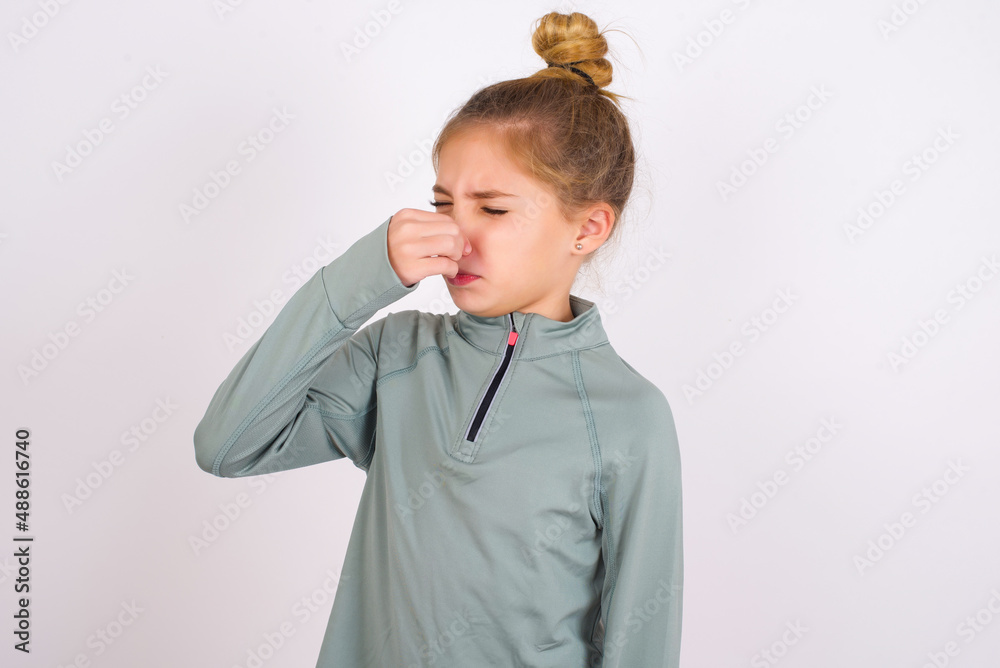 little caucasian kid girl with hair bun wearing technical shirt over ...