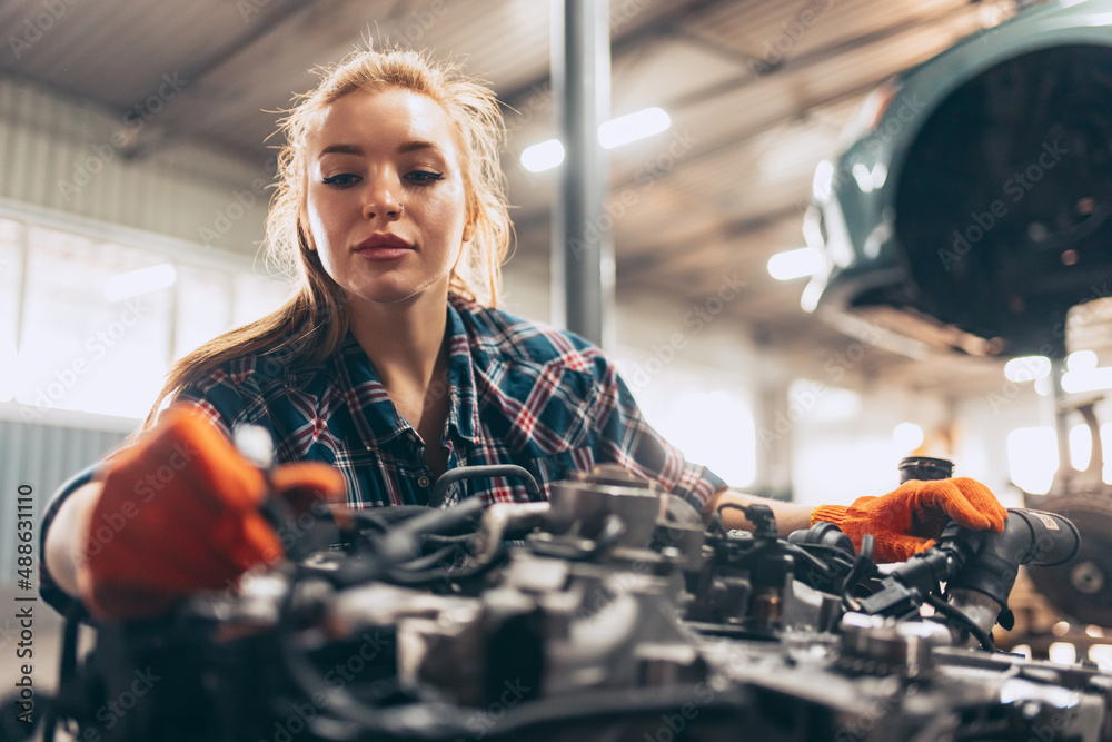 Destroying gender stereotypes. Young woman auto mechanic working at ...