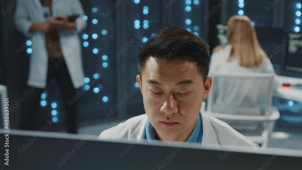 Asian IT programmist typing server data on software desktop computer ...