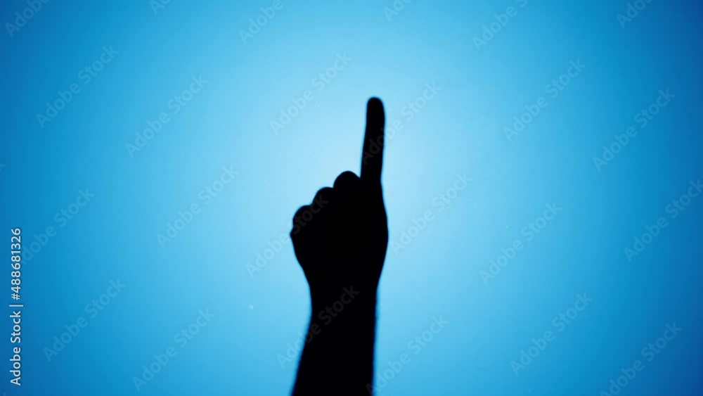 Man showing forefinger raised on blue neon background. Shadow of first ...