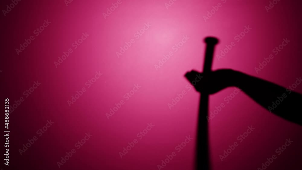 Man holding baseball bat close-up, shadow silhouette of hand with ...