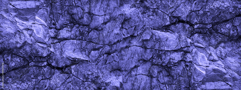 Light purple blue rock background. Wide banner. Toned cracked mountains ...