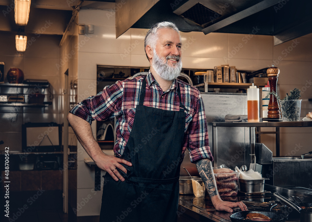 Professional elderly butcher inside modern kitchen of restaurant Stock ...