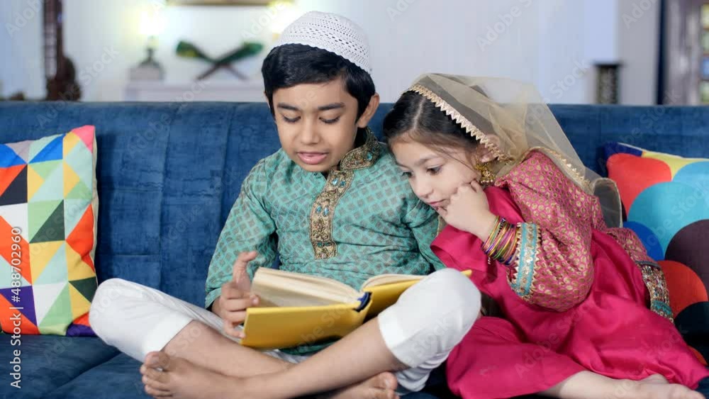 Cute Muslim siblings reading the Quran together at home - Holy book of ...