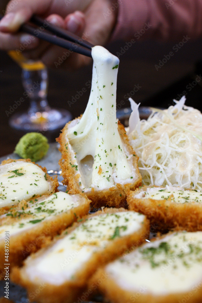 Extend the cheese inside the full pork cutlet with chopsticks. Stock ...