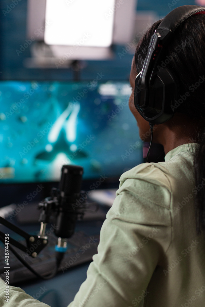 Successful gamer woman with gaming headset while playing online ...