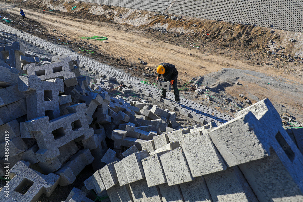 Workers are building river slope protection at a water conservancy ...