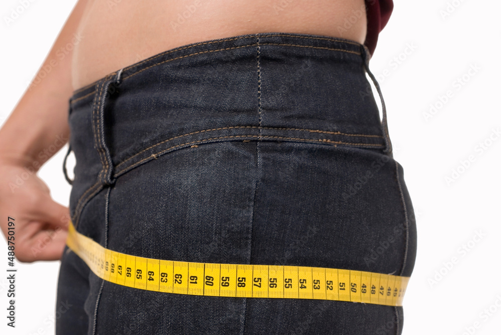 Young woman with a measuring tape as a symbol for body cult, diet and ...