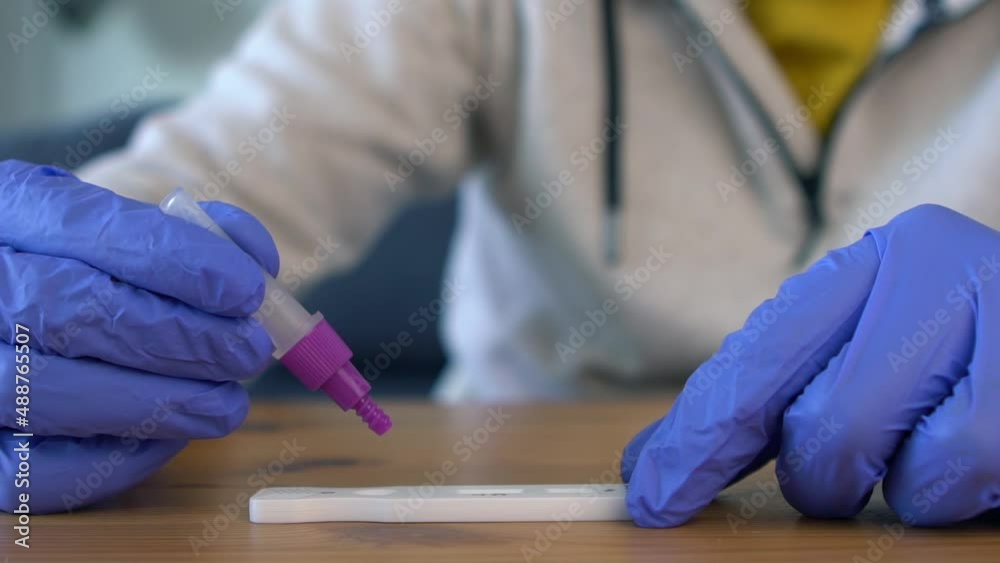 Slowmotion of man wearing latex gloves placing the sample into covid-19 ...