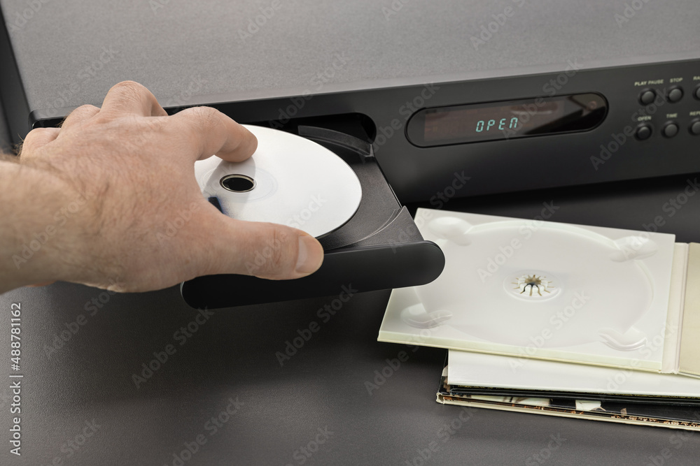Hand of a man with a disc, an open tray of a CD player. Stock Photo ...