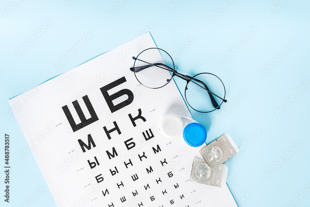 A table for checking vision in Russian, glasses and lenses on a light ...