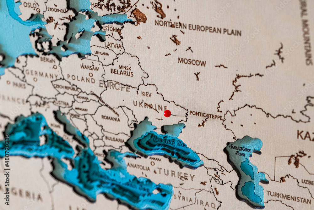 Wooden map of Europe with a pin in the conflict zone in eastern Ukraine ...