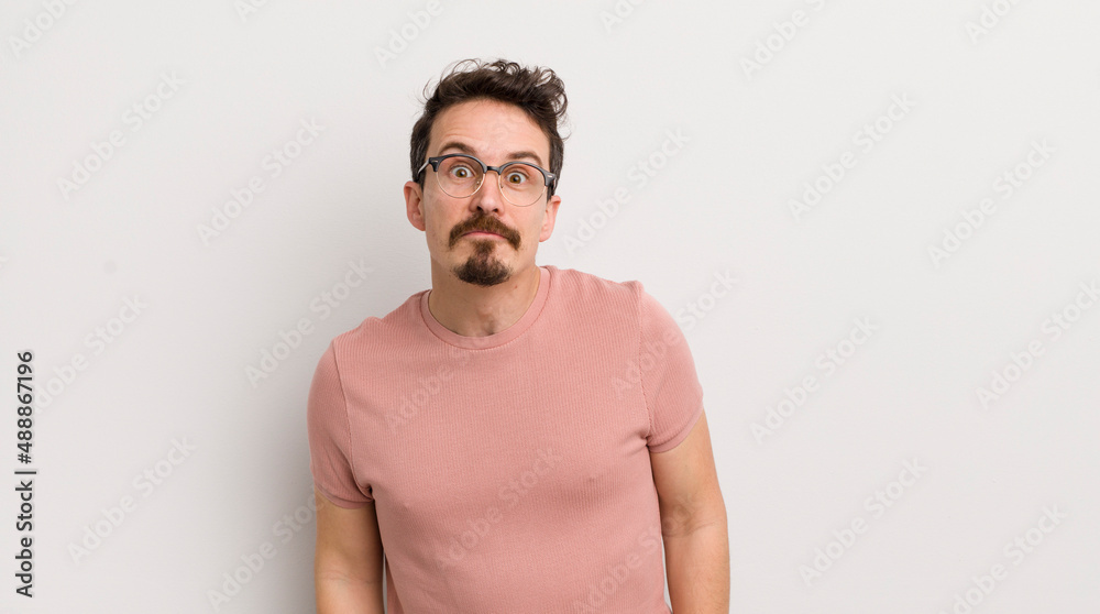 hispanic young man with a goofy, crazy, surprised expression, puffing ...