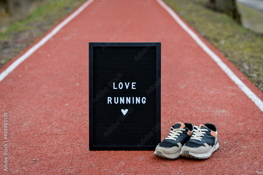 'Love running' letters on black letterboard put on running track with ...