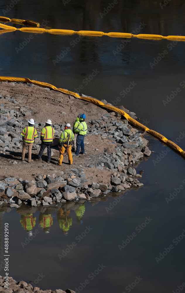 Foto de Construction Workers at Bridge Work Site on River With Oil ...