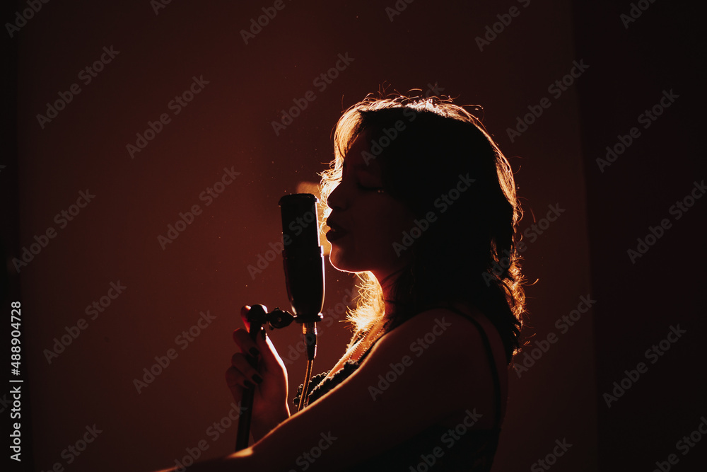 silueta de Joven cantante apasionada a contraluz foto de Stock | Adobe ...