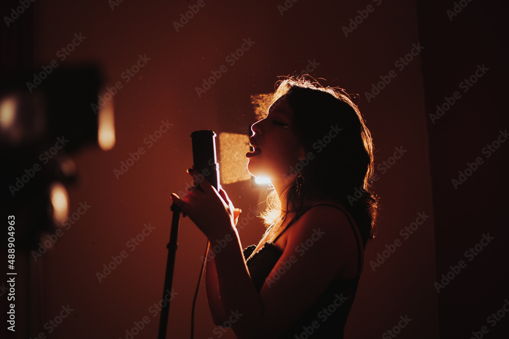 silueta de Joven cantante apasionada a contraluz Stock Photo | Adobe Stock