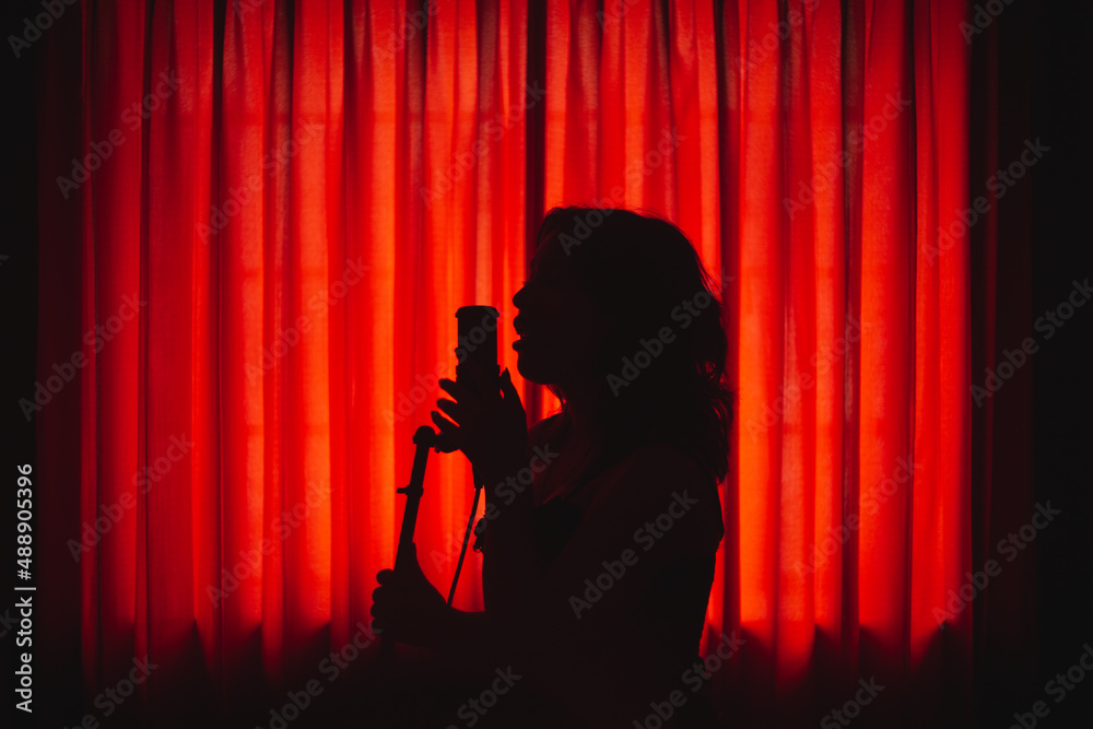 Silueta de joven cantante con fondo rojo Stock Photo | Adobe Stock