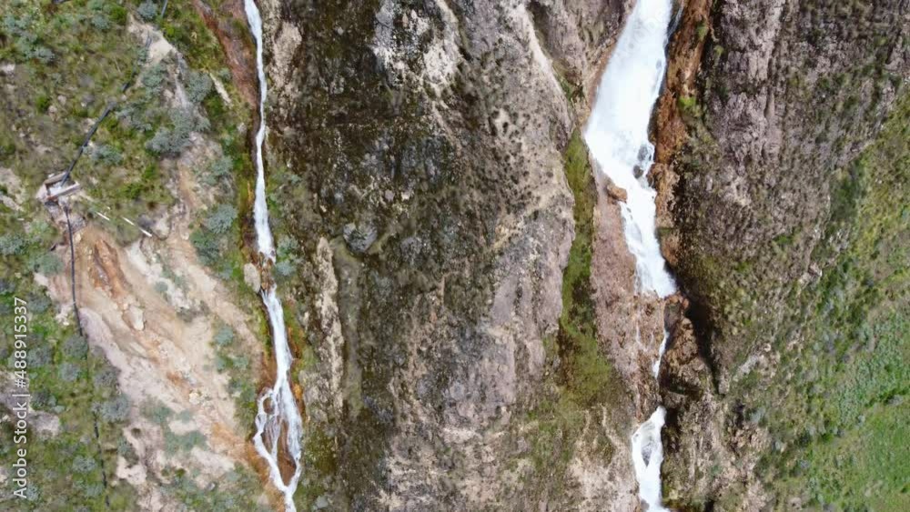 Drone footage shot from the top of a waterfall. Slowly tilting up ...