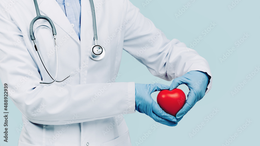 Female doctor in white uniform forms a heart shape with her hands ...