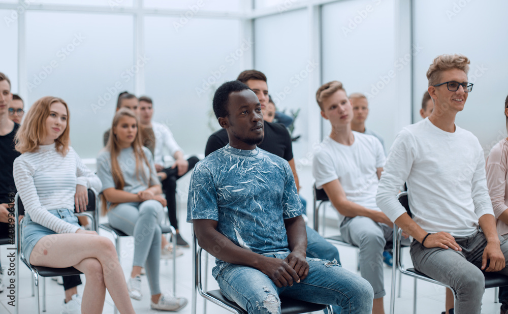 diverse young people sitting on chairs in the conference room. Stock ...