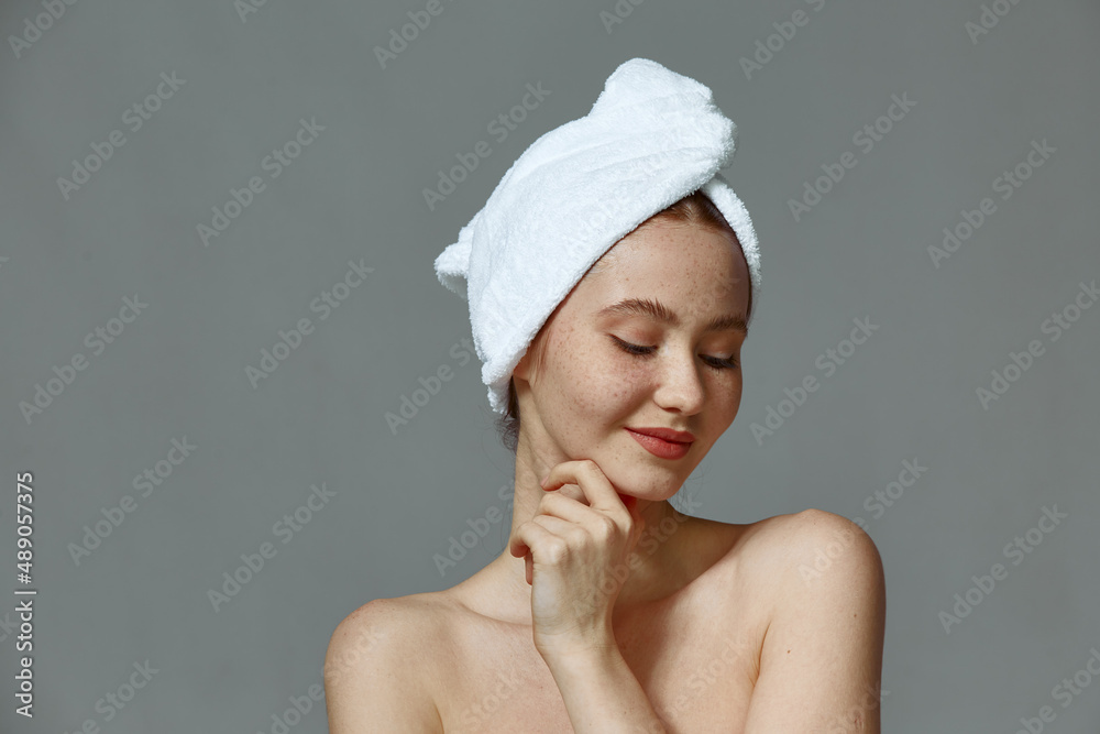 Young woman with perfect smooth face skin, bare shoulders, towel on ...