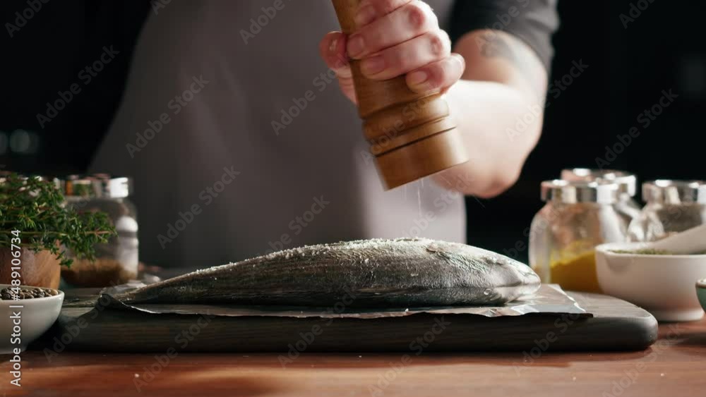 Woman cooking fish close-up. Professional chef preparing fish in ...