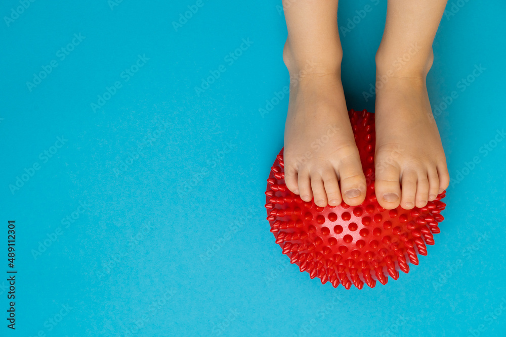 Children s Feet With A Red Balancer On A Light Blue Background children-s-feet-with-a-red-balancer-on-a-light-blue-background