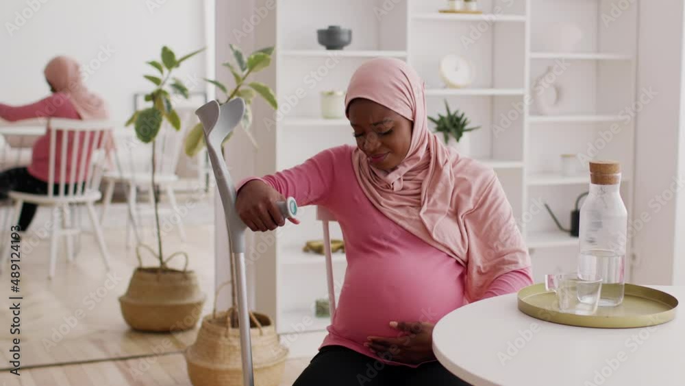 Pregnant African Lady Holding Crutches Touching Belly Feeling Pain ...