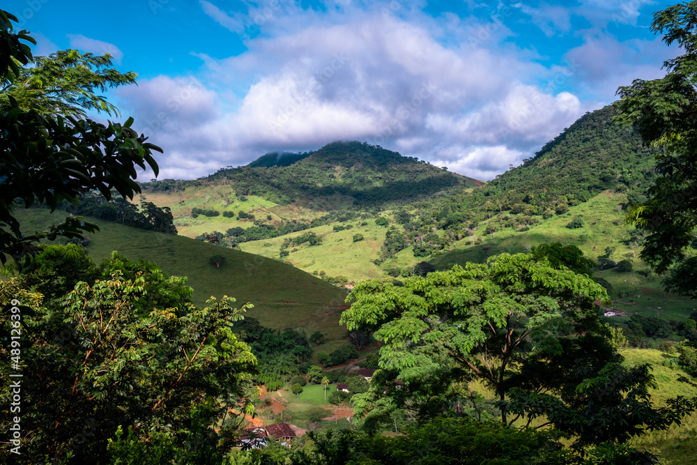Beautiful valley under a mountain. Cloudy sky and fog. Green valley in ...