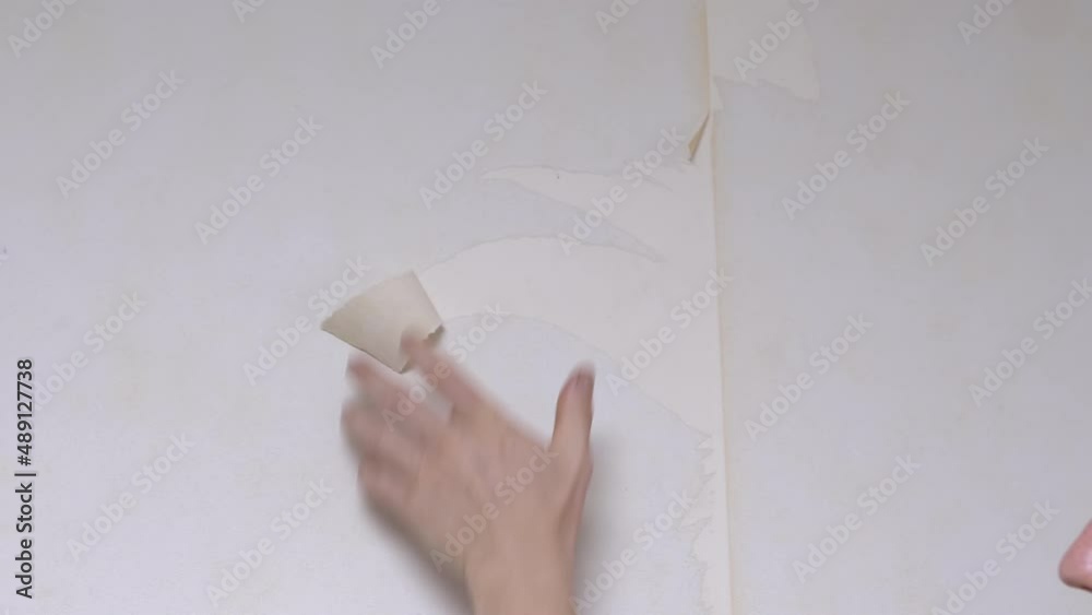 Stockvideo Male Removing Off Old Paper Wallpaper on the Wall. Master ...