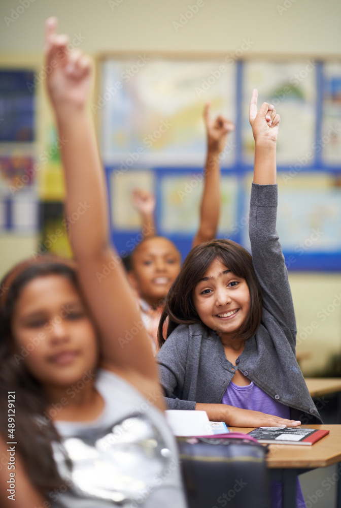 They all know the answer. A group of students raising their hands in ...