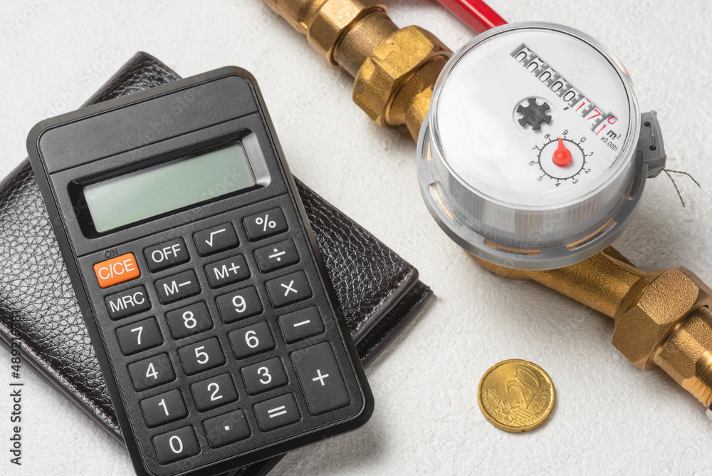 Water supply costs concept. Water meter, calculator and wallet close up ...