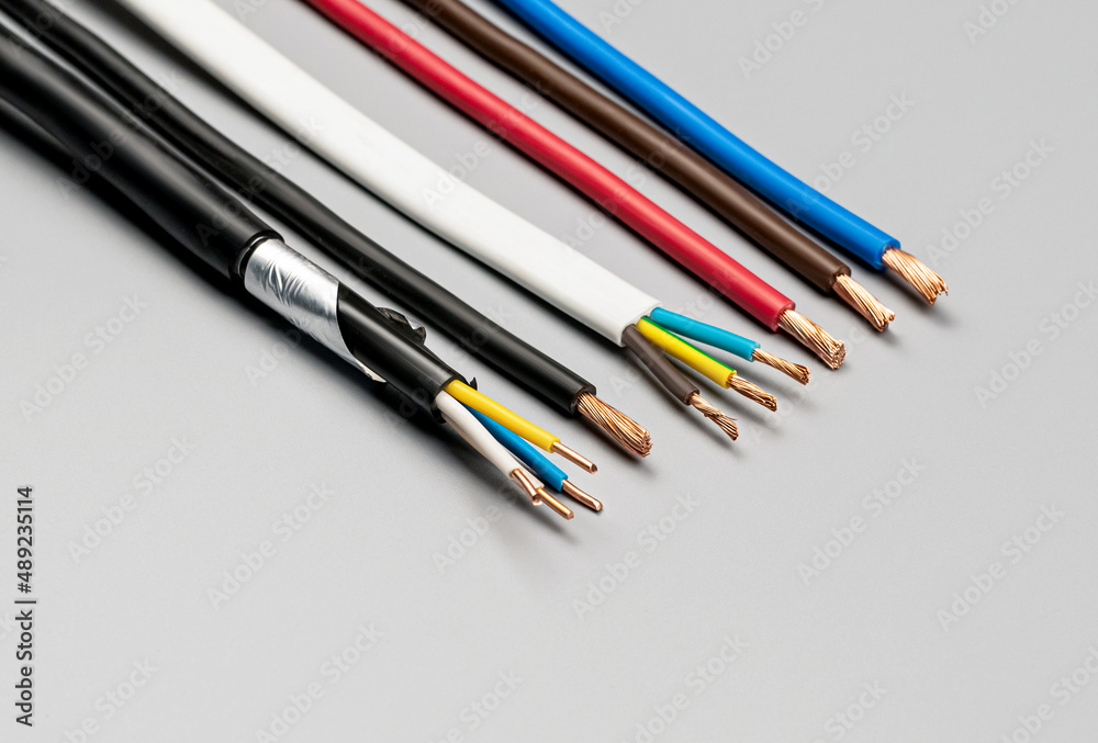 Different types of copper wires with insulation on a gray background ...