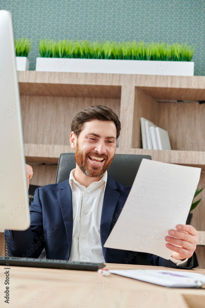 Overjoyed young male manager in formal suit reading unexpected win in ...