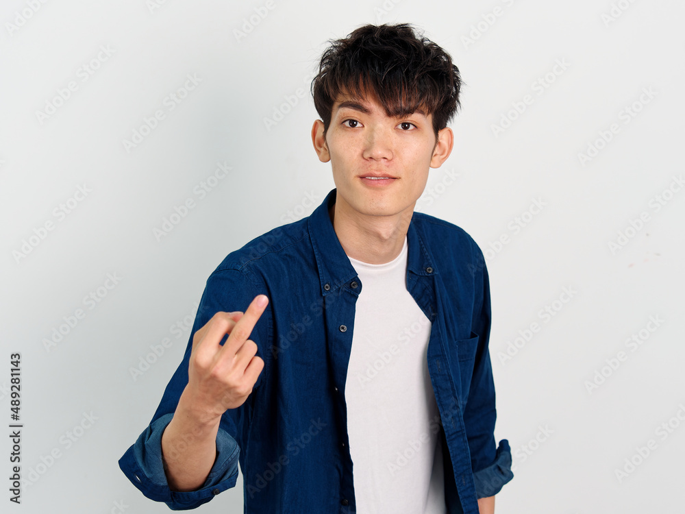 Portrait of handsome Chinese young man with curly black hair in blue ...
