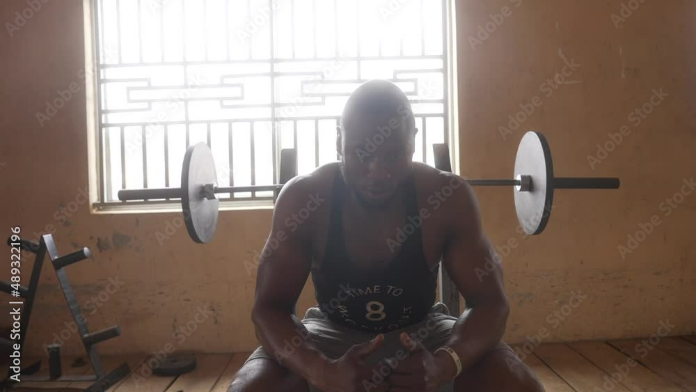 Black man focused and looking to the camera in a poor old school gym ...