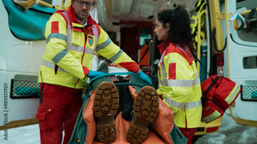 Emergency Care Workers Pushing a Stretcher Into The Ambulance Car After ...