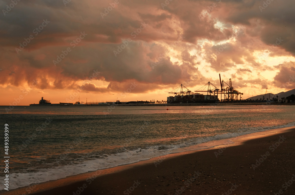 Colorful sunset over sea port and industrial cranes. Coastline of beach ...