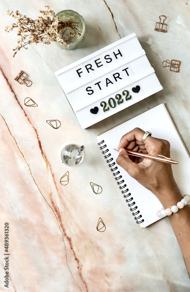 Top view of a person writing her plans in a notebook - fresh start for ...